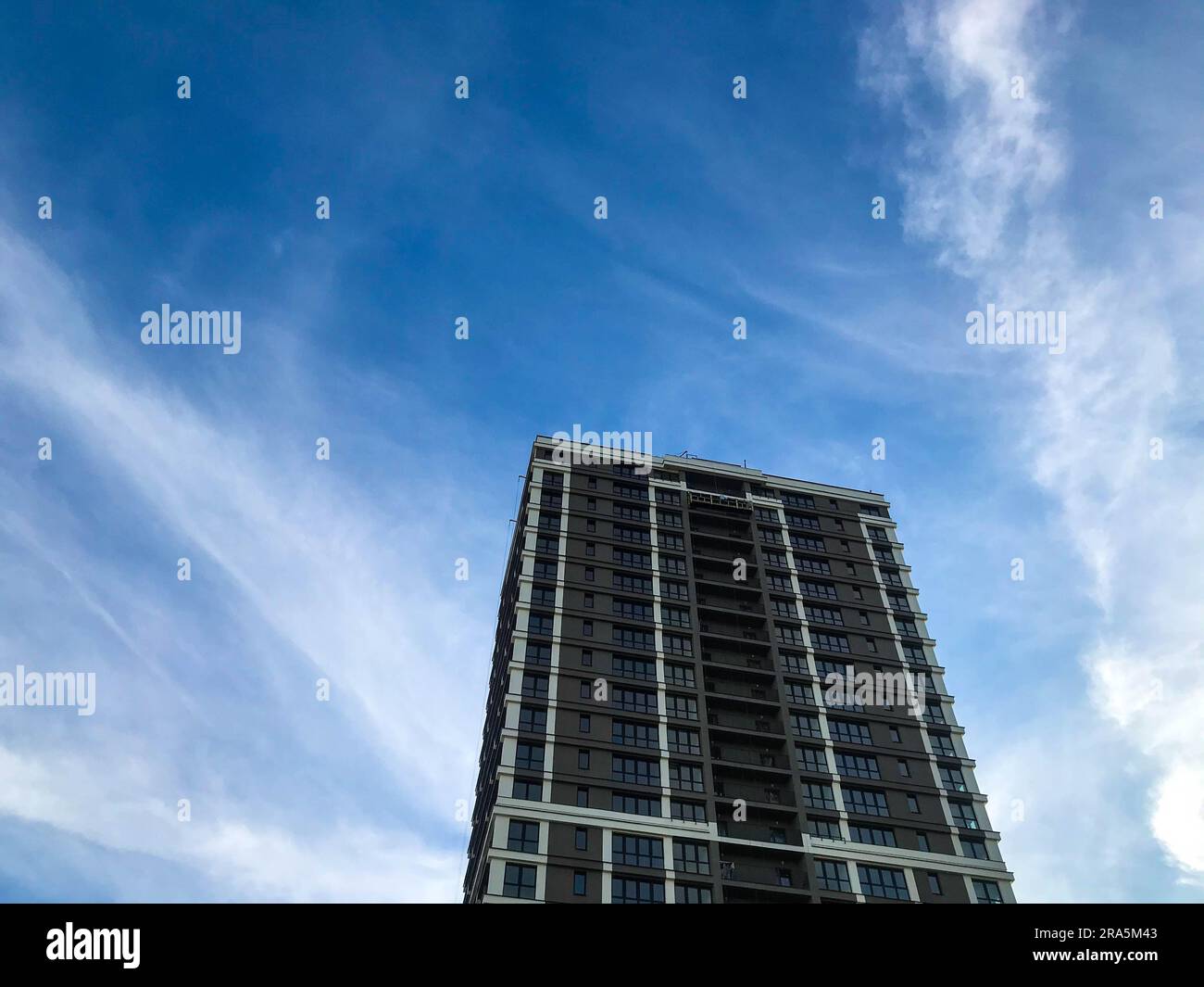 a tall, multi-storey glass building in a white and brown city. the ...