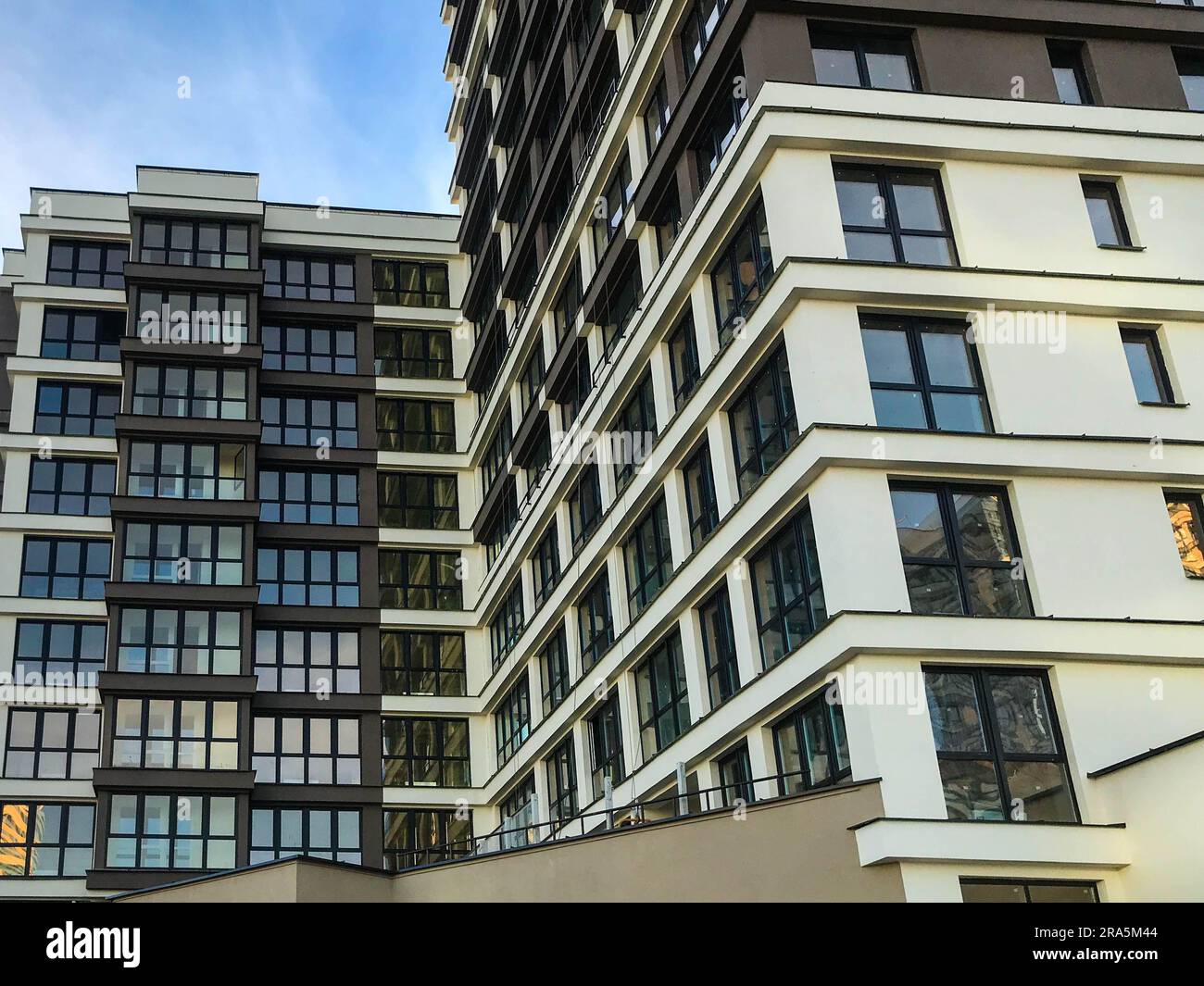 a multi-storey building with many windows stands in the city. brown and ...