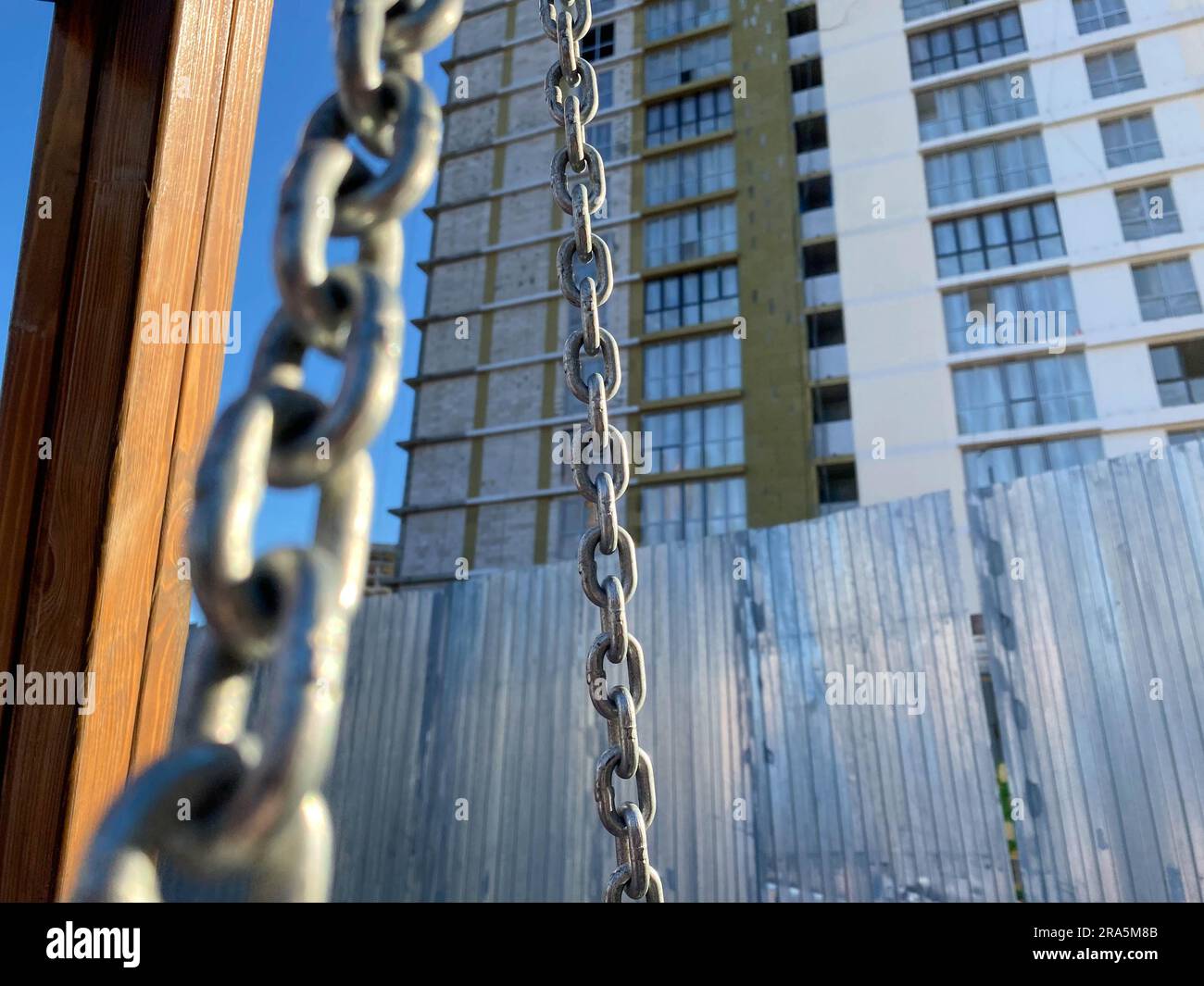 Iron chains on the background of a new house on a construction site ...