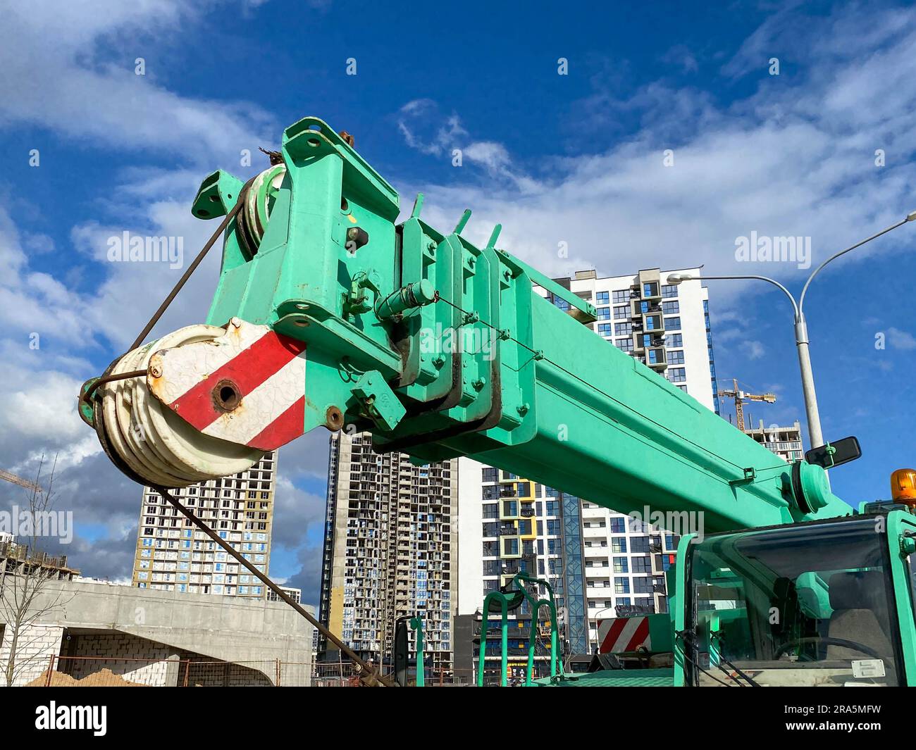 Large powerful new industrial green construction crane used in the construction of new areas of ...