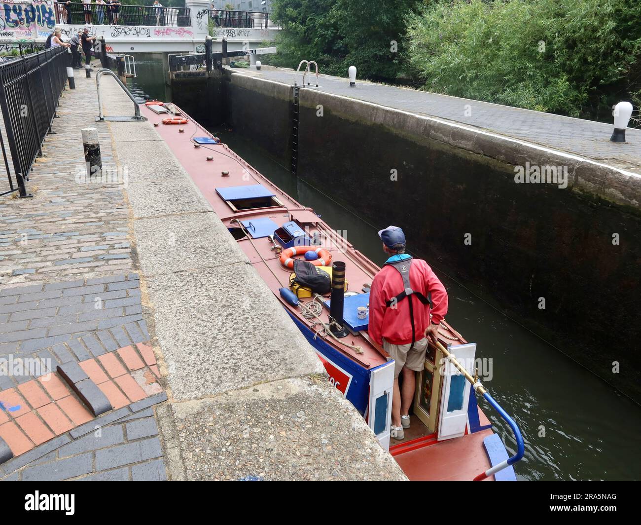 London, UK - June 2023 : Man steering a barge out of a lock, Camden ...