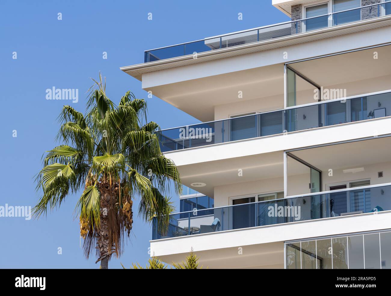 New apartment building with large balconies with glass railings. Modern ...