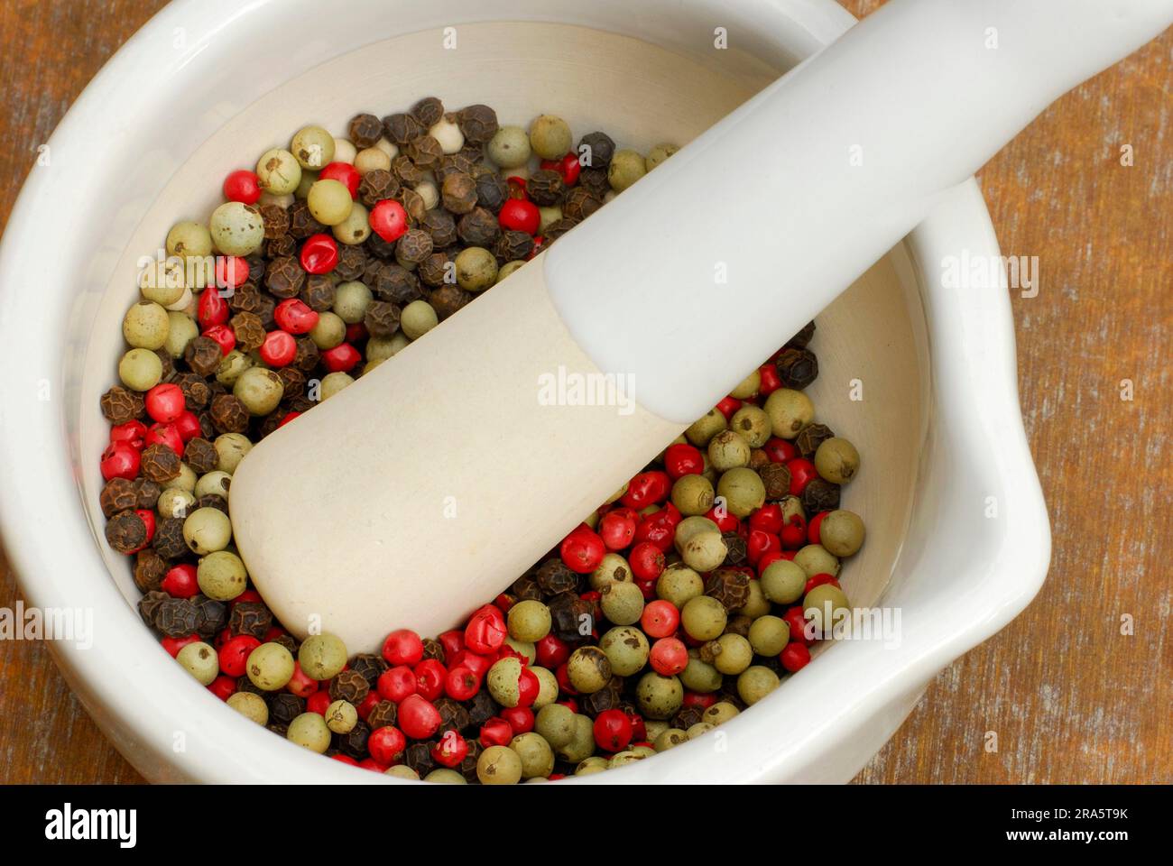 Black, white and red pepper, mortar and pestle Stock Photo - Alamy