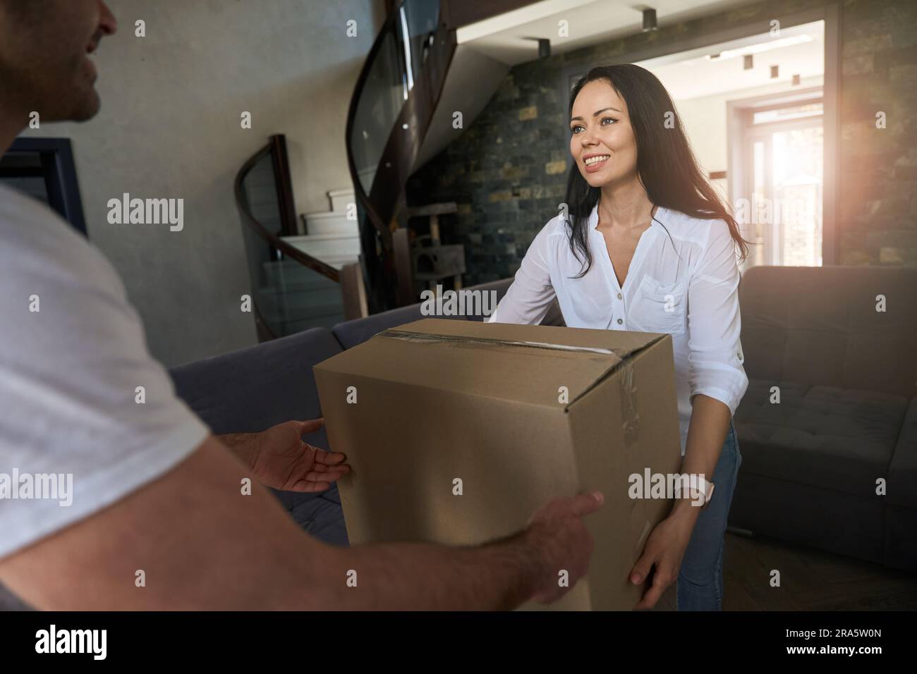 Young woman giving a box to a man Stock Photo - Alamy