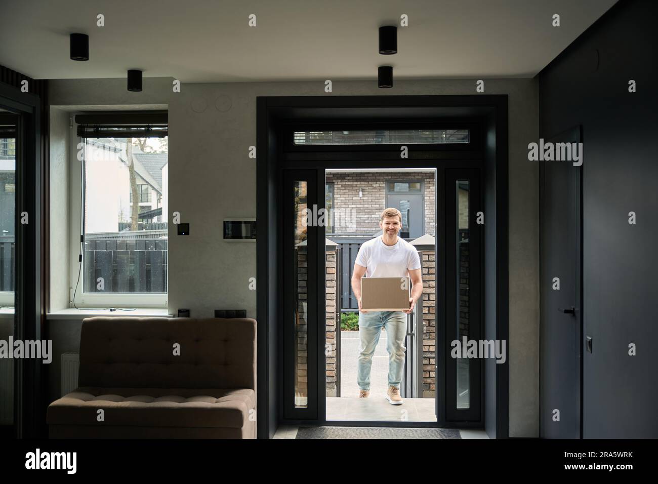 Man brings boxes into the house when moving Stock Photo - Alamy