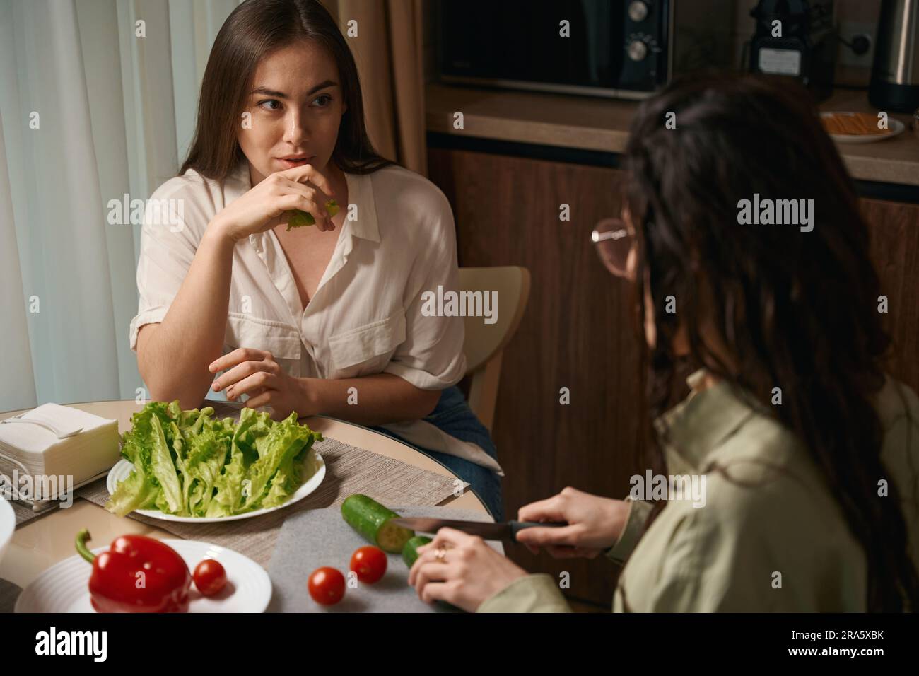 Women talking at table in the kitchen Stock Photo - Alamy