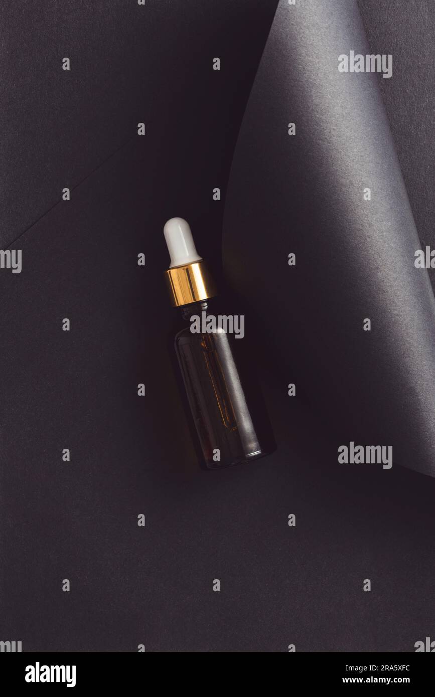 No name glass oil dropper bottle on black paper background Stock Photo ...