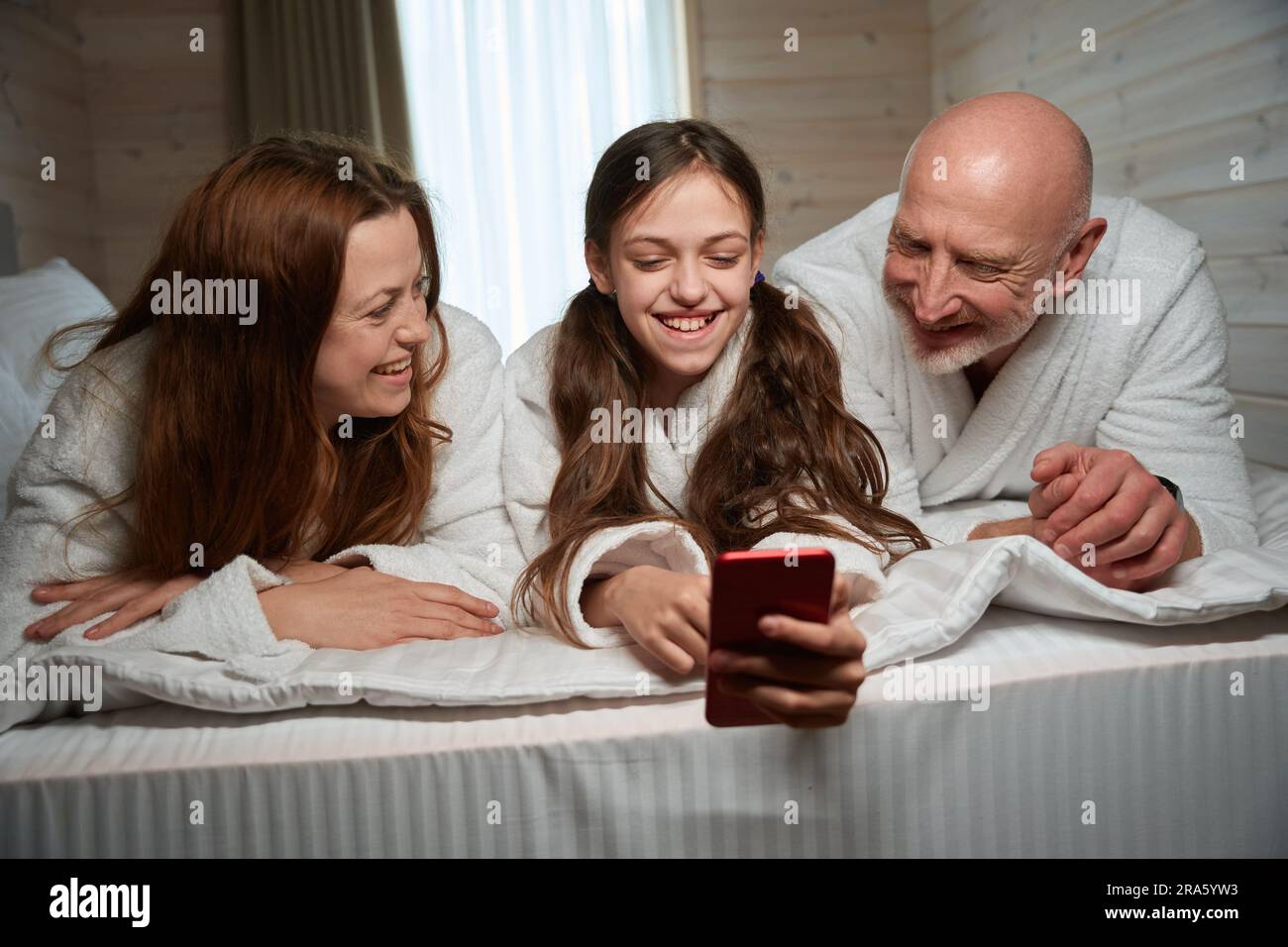 Cheerful teenage girl spending time with mom and dad indoors Stock ...