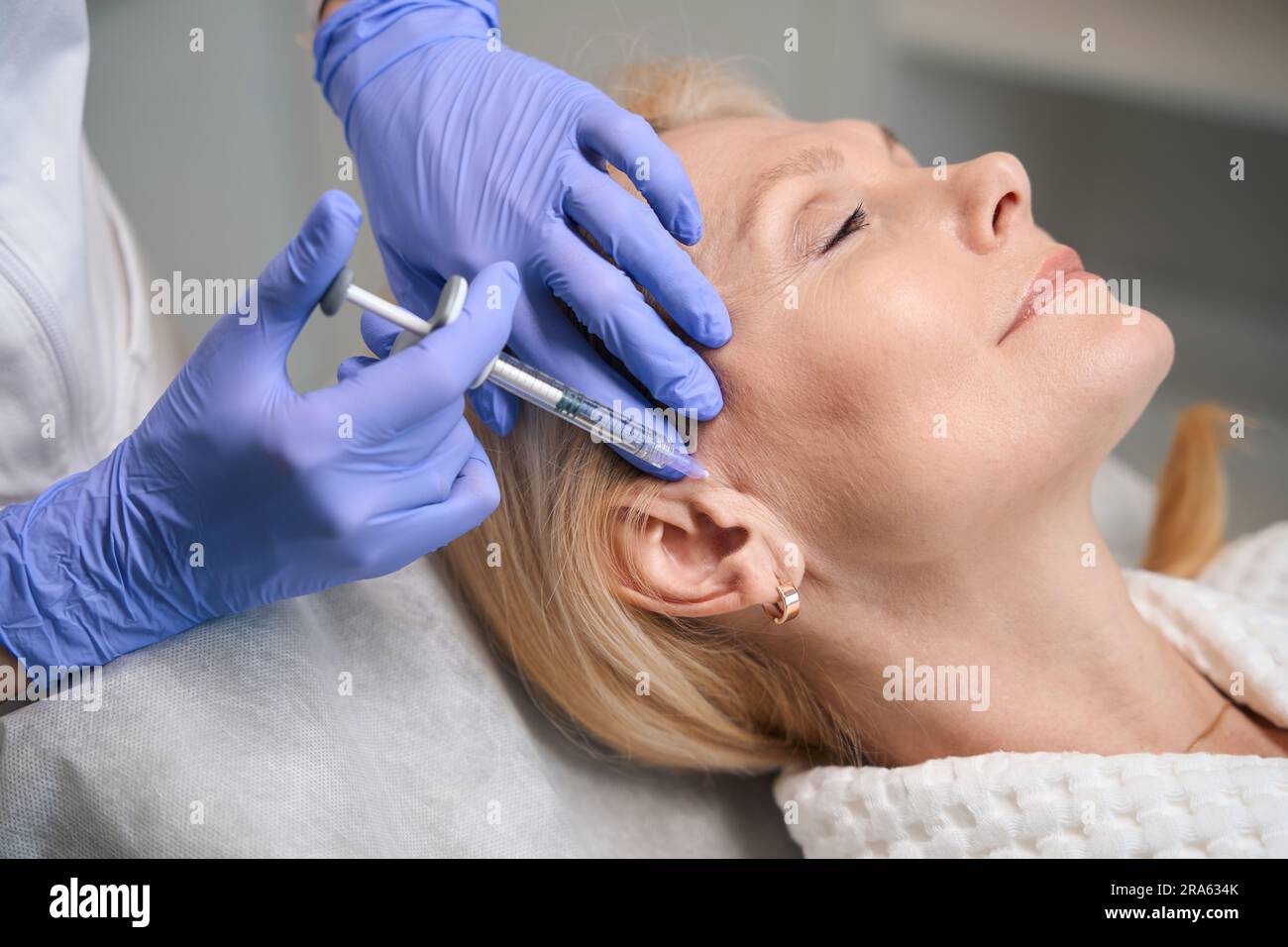 Adult woman getting temple injection in beauty salon Stock Photo - Alamy