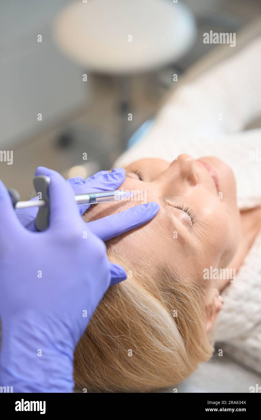 Adult woman getting face injection in beauty salon Stock Photo - Alamy