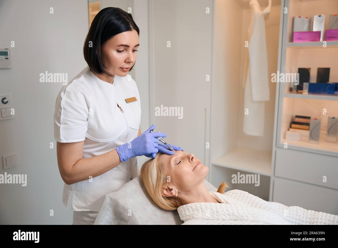 Beautician performing injection on client interbrow area Stock Photo ...