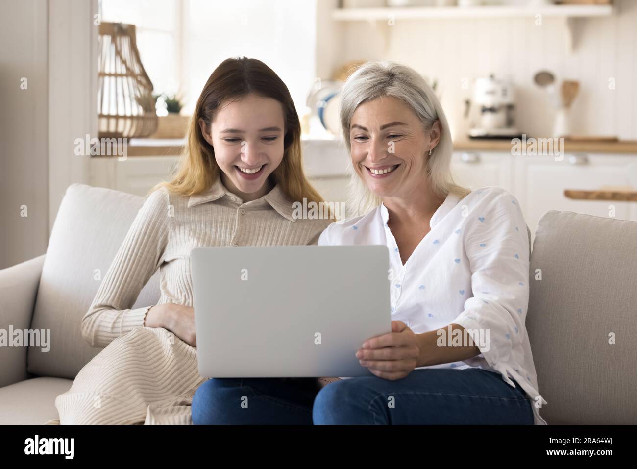 Happy Teen Girl And Cheerful Grandma Having Fun On Home Couch Stock