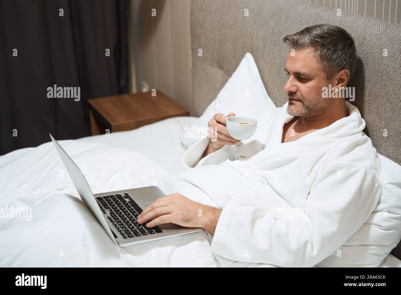 Man lying and watching movie on computer Stock Photo - Alamy