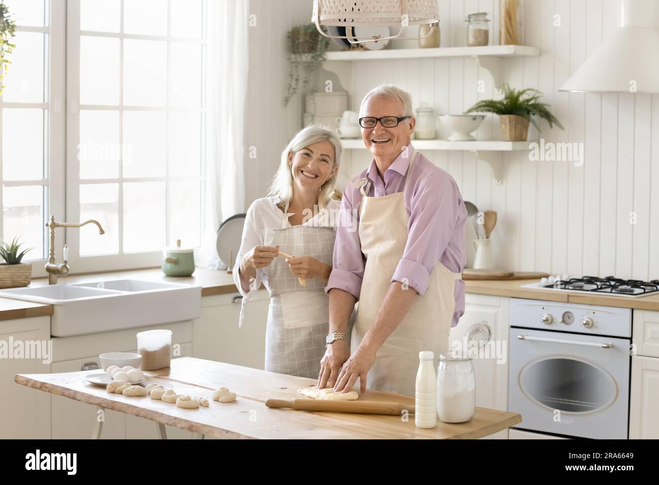 Positive retired grey haired couple enjoying cooking culinary ...