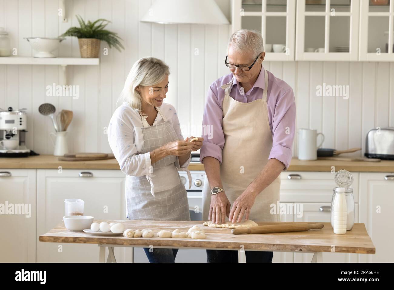 Positive mature wife helping senior baker husband with bakery ...