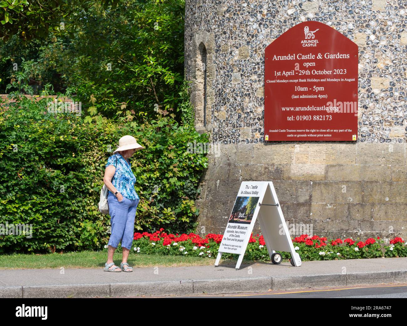 Senior lady standing looking at closed sign at tourist attraction ...