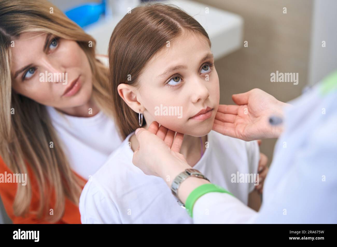 Pediatrician touching little girl neck, examining lymph nodes Stock ...