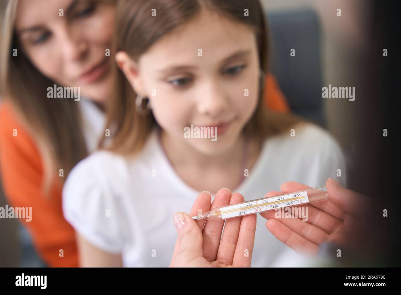 Caring woman physician checking body temperature of little girl Stock ...