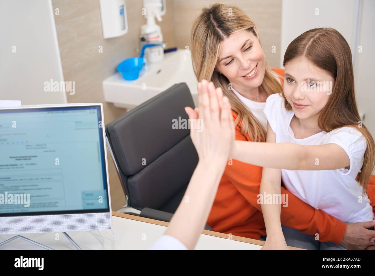 Girl patient of private clinic giving high-five to therapist Stock ...