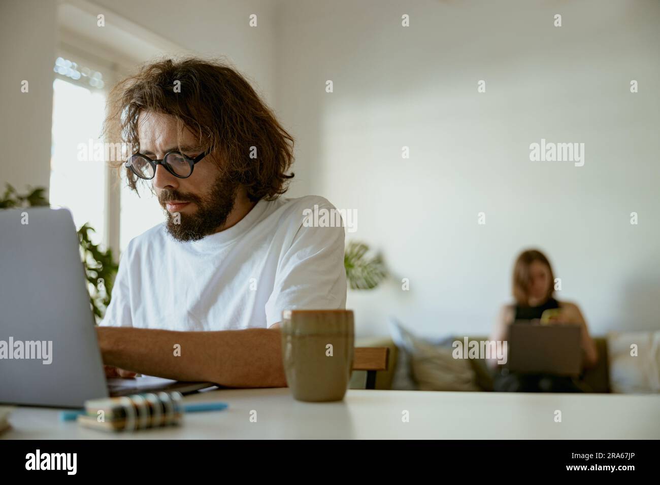 Young family couple working from home office and using laptops ...