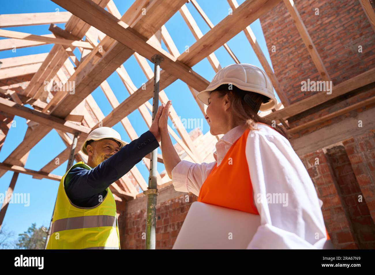 Positive building engineers team giving high five to each other Stock ...