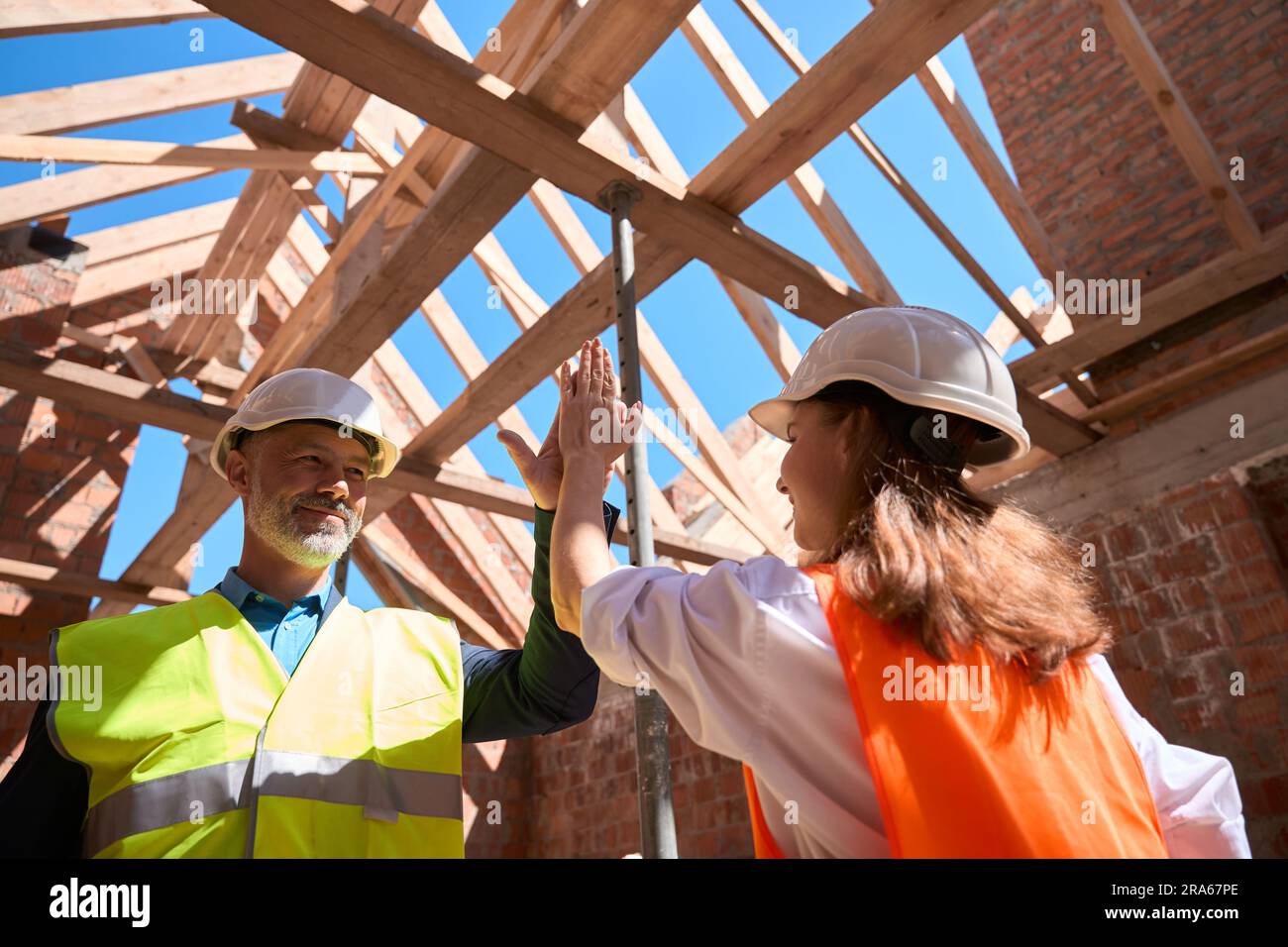 Manager and general constructor giving high-five, finishing wall ...