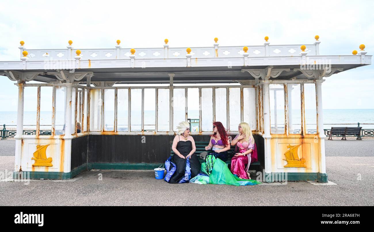 Brighton UK 1st July 2023 - Mermaids have time for a chat before taking ...