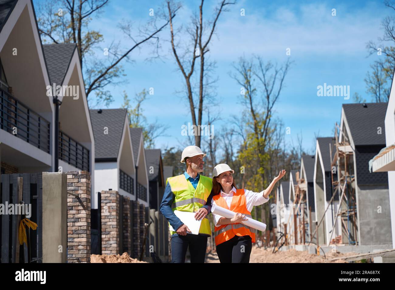 Main construction worker showing construction site to housing developer ...