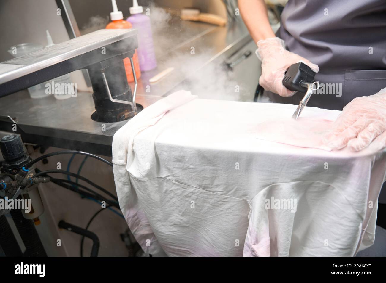 Skilled dry cleaner removing stains using steam gun Stock Photo - Alamy