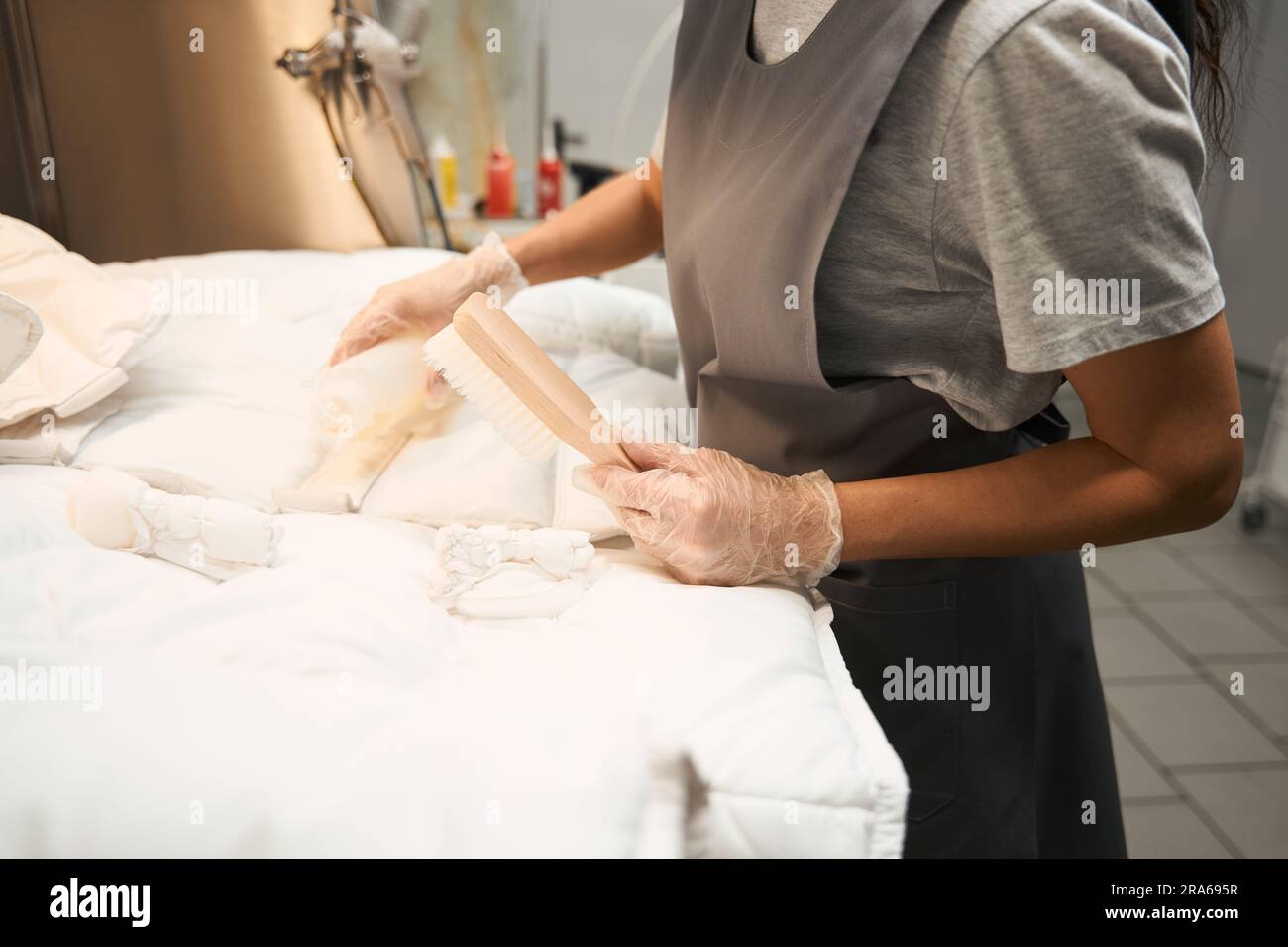 Dry-cleaning lady pouring stain removal solvent at coat and cleaning ...