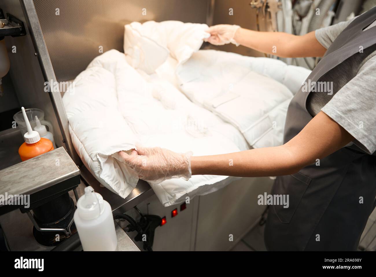 Lady dry-cleaning office worker inspecting jacket on stains presence ...