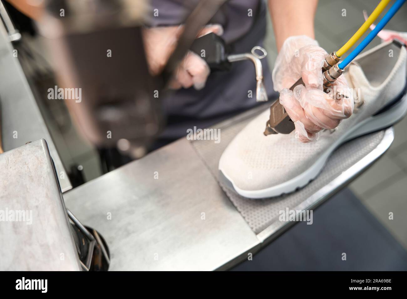 Woman cleaning sneakers with spot cleaning spray gun and steam gun ...