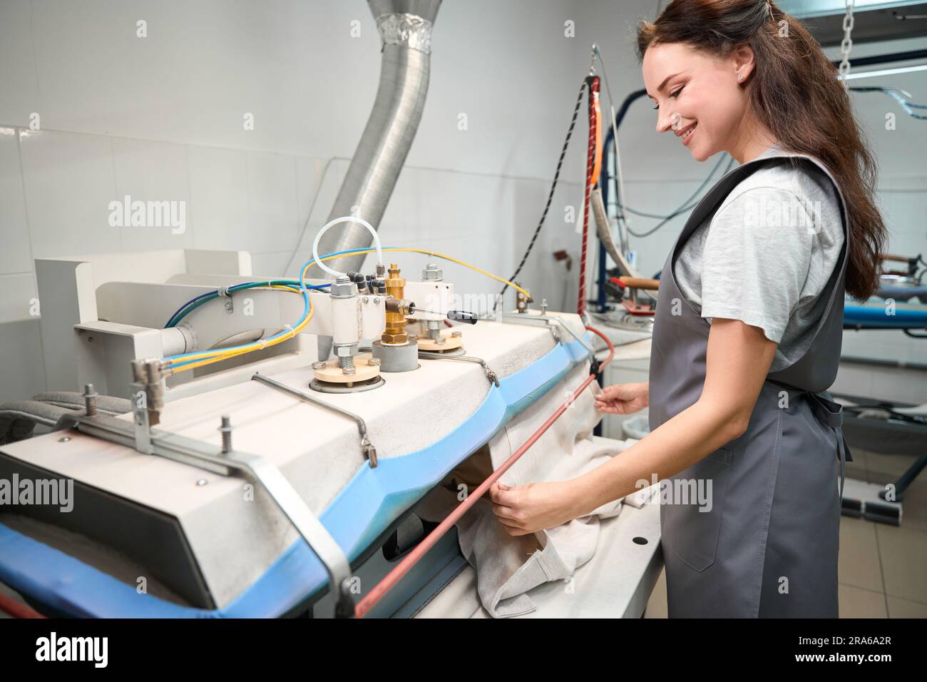 Laundry service worker using steam press for shaped-fixing and ironing ...