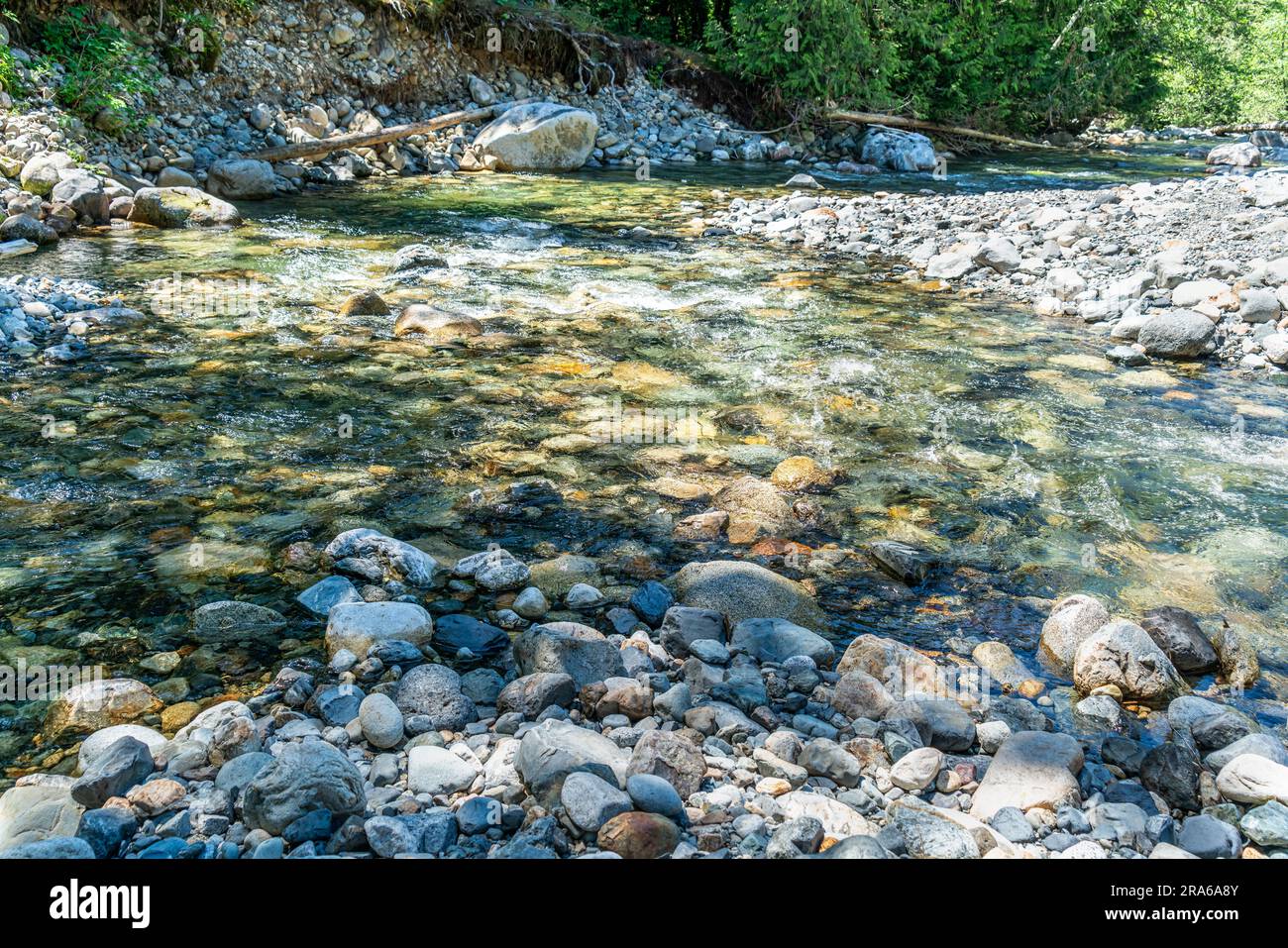 Clear mountain water flows over rocks in Denny Creek in Washington ...