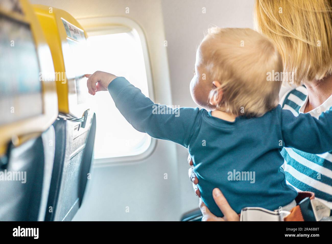 Mom and child flying by plane. Mother holding and playing with her ...