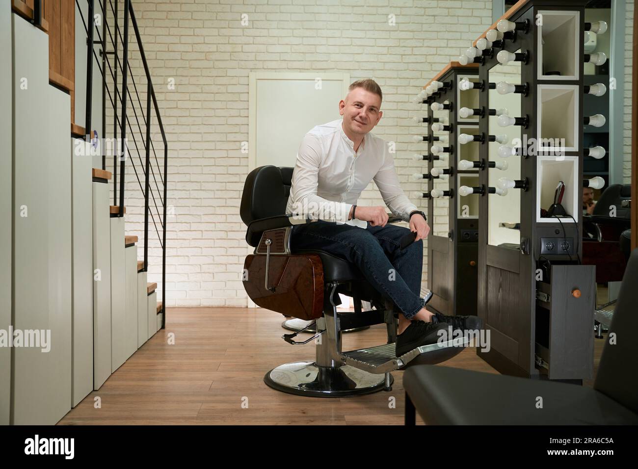 Man barber sits in a barber chair at his workplace Stock Photo - Alamy