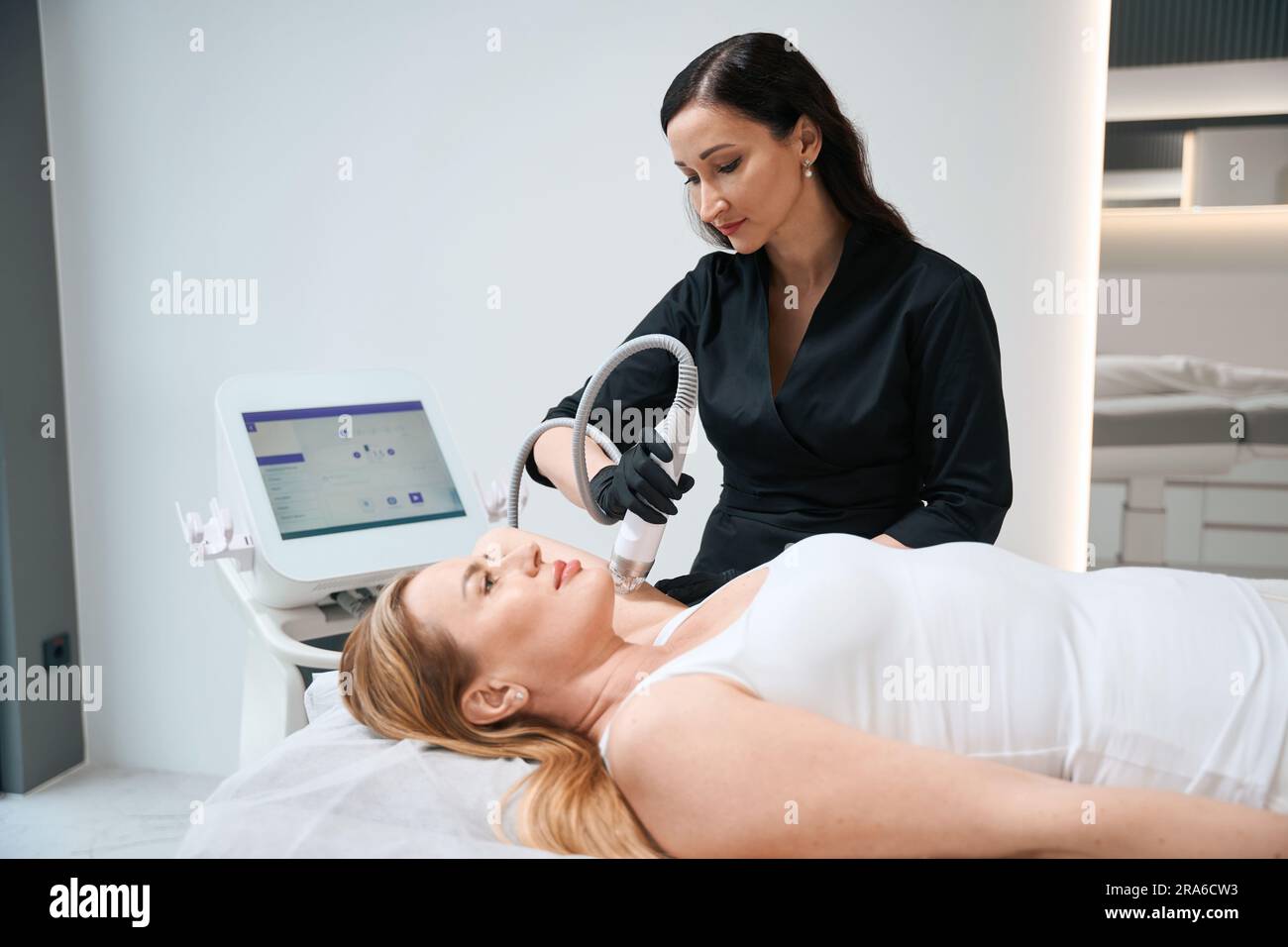 Young female performs effective RF lifting procedure on shoulder area ...