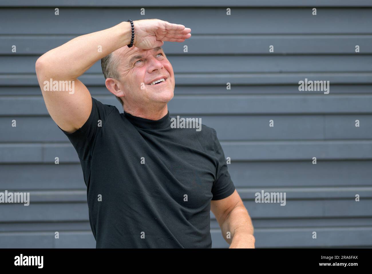 Portrait of an elderly man looking interested at the sky and a hand on ...