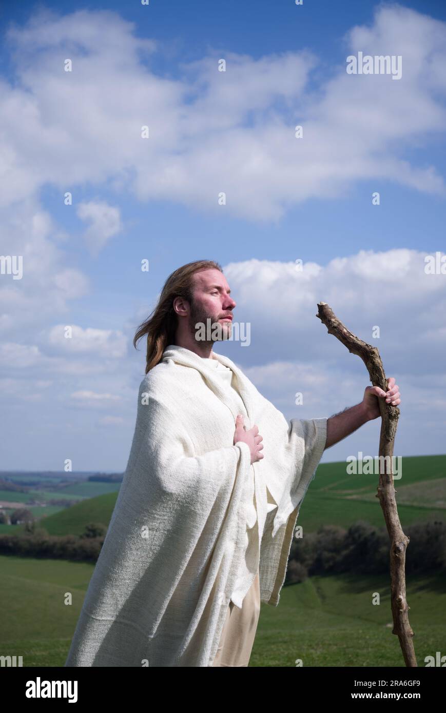 White European Jesus Christ holding a staff in a landscape wearing ...
