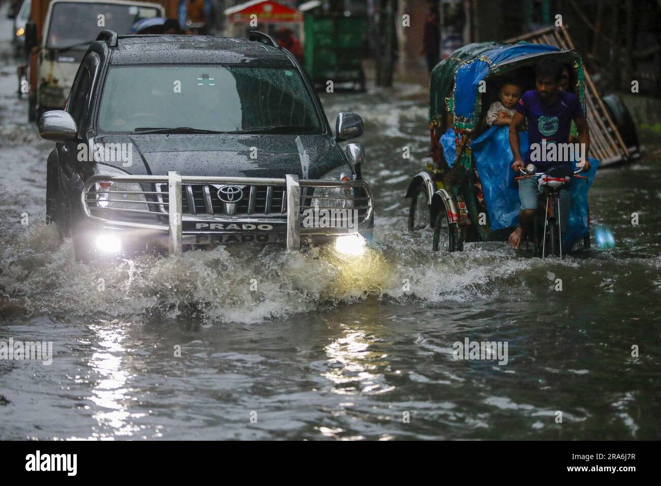 Dhaka, Bangladesh. 01st July, 2023. Vehicles make their way through a waterlogged street after ...