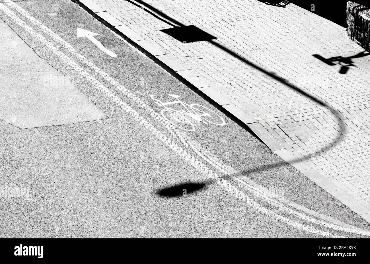 Shadows and road markings on city street, bike lane and sidewalk in ...