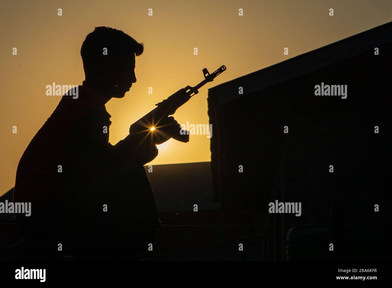 A Kashmiri Muslim boy is silhouetted against the setting sun as he ...