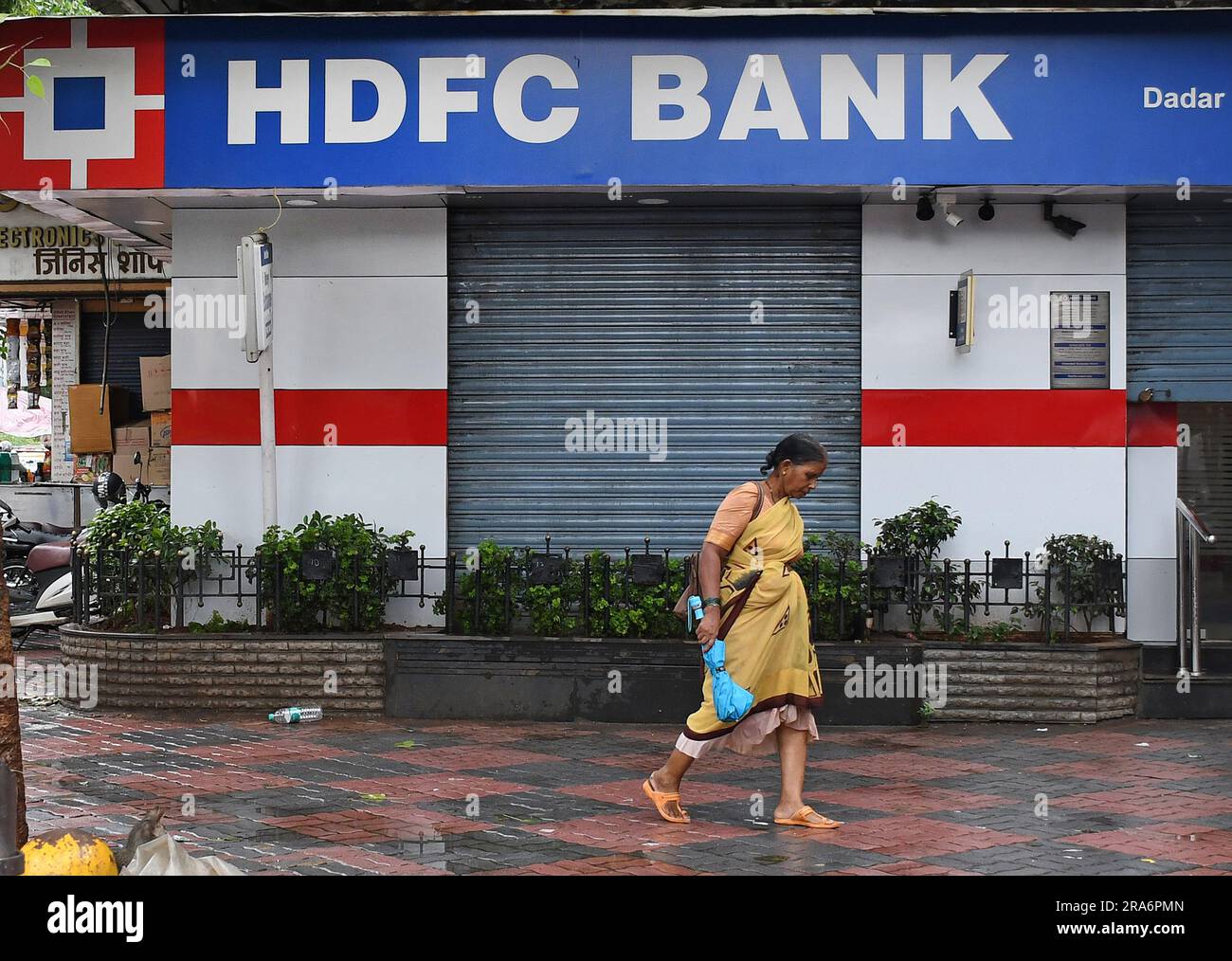 Mumbai, India. 01st July, 2023. A woman holding an umbrella walks past ...
