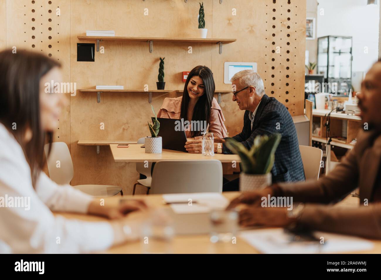 Senior businessman joking while explaining marketing strategy to his ...