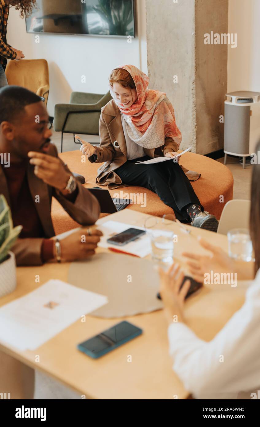 Smiley, muslim ginger business girl writing notes on a document while ...