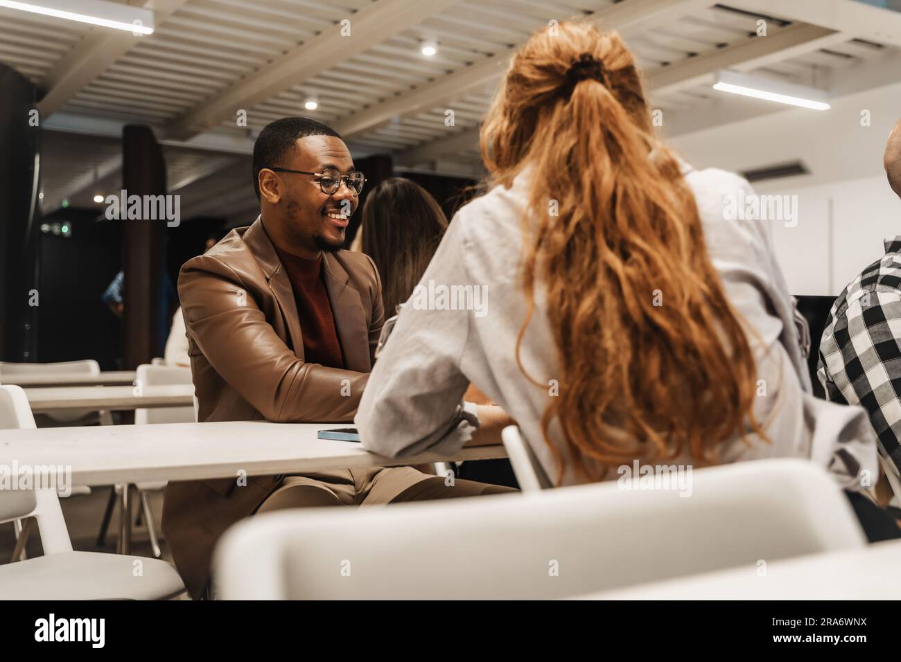 Two coworkers having a conversation at the classroom. Handsome black ...