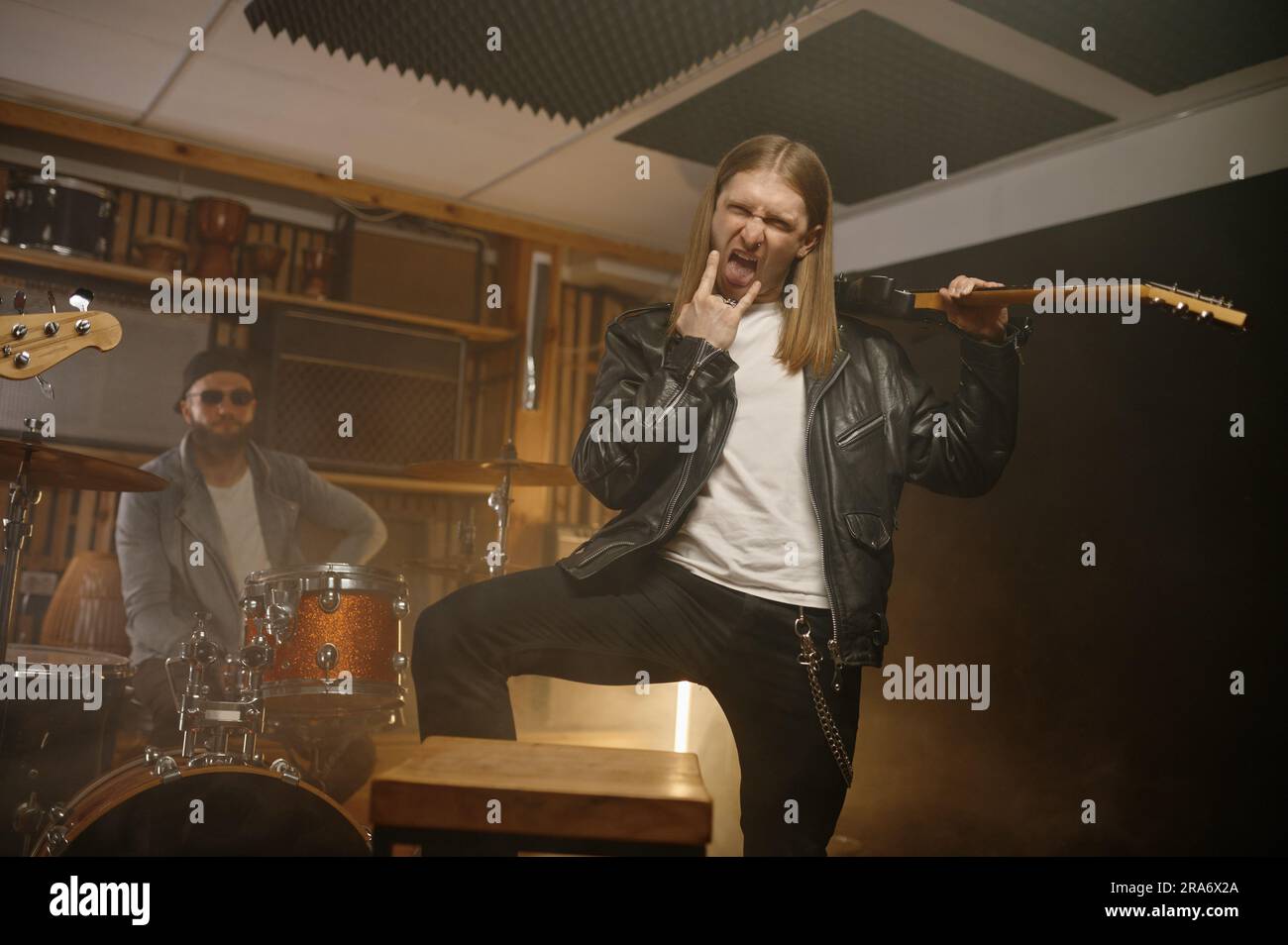 Excited expressive rock guitarist gesturing fist with rock-and-roll ...