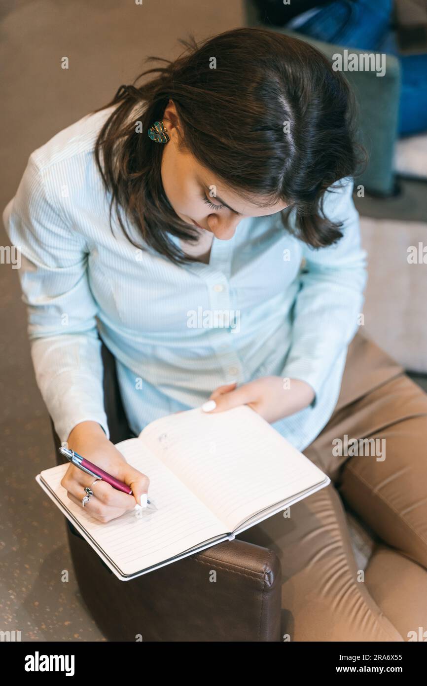 Above photo of girl writing in notebook Stock Photo - Alamy