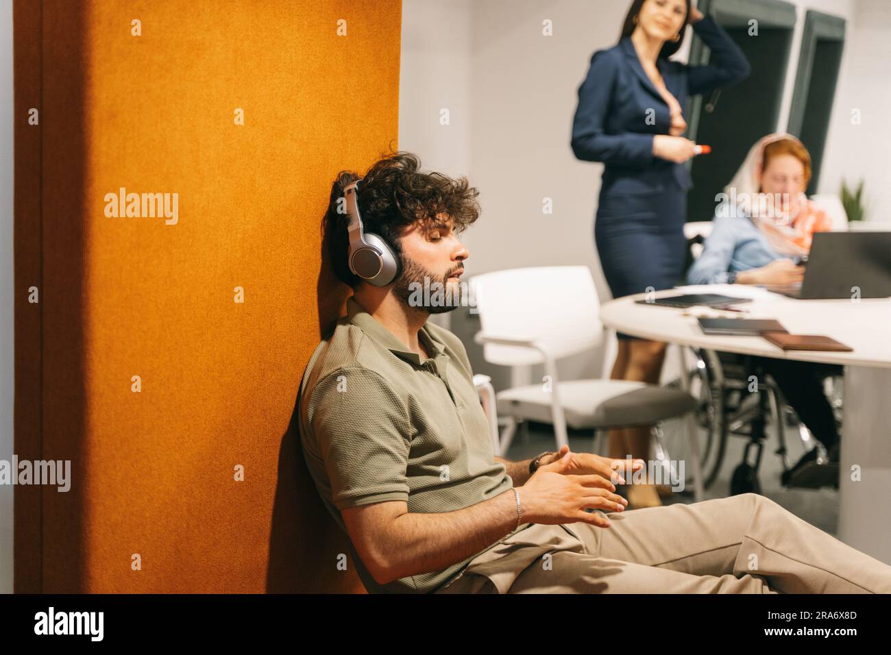 Good looking employee listening to music on headphones. Dancing moves ...