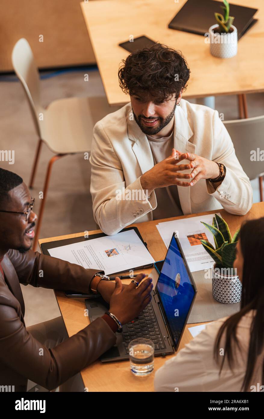 Friends working together and talking at the cafe Stock Photo - Alamy